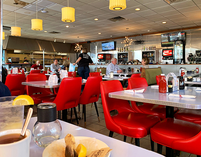 Where locals gather and visitors become regulars. The red chairs have witnessed countless coffee refills and life stories.