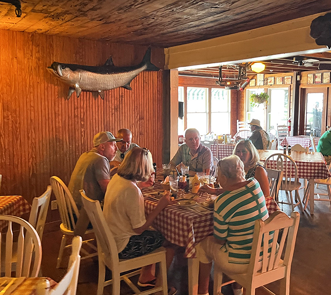 The true Florida dining experience: mounted fish watching over your meal like aquatic guardian angels while red-checkered tablecloths promise home-style goodness.