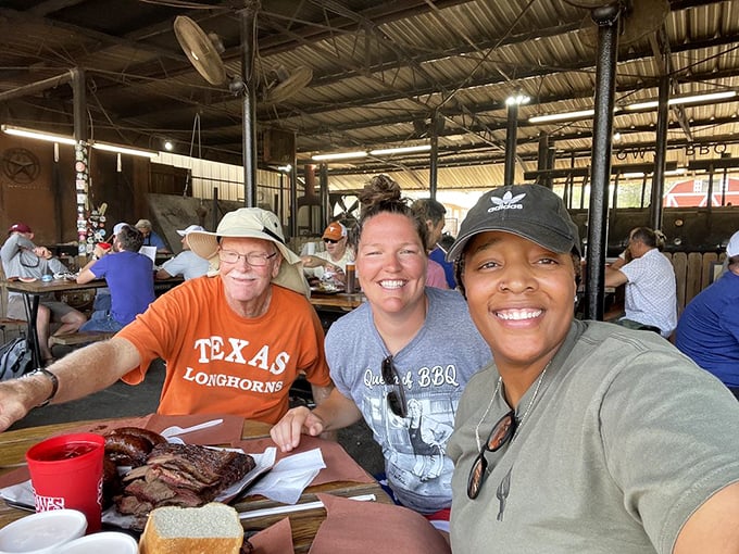 Happy faces around the table – the universal language of barbecue satisfaction transcends all boundaries at this humble smoke shack.