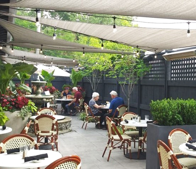 The outdoor patio offers a garden oasis where diners can enjoy their steaks al fresco, surrounded by greenery that somehow makes eating meat feel virtuous.