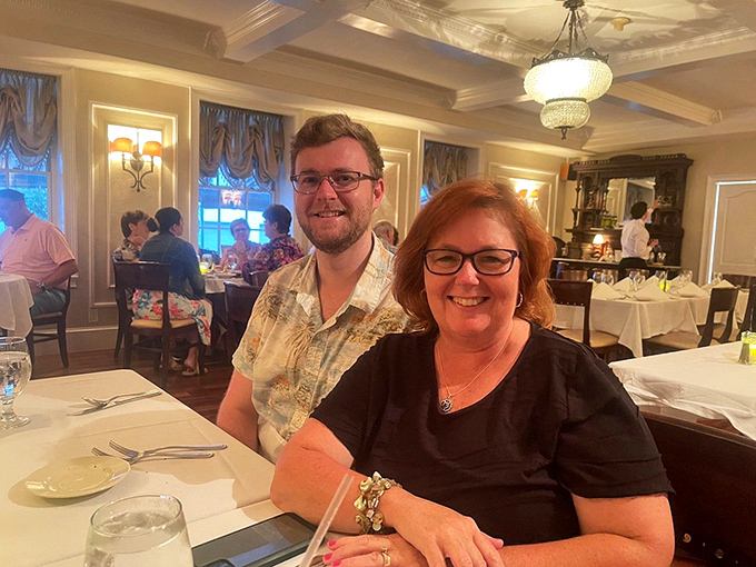 Happy diners experiencing what we've all missed – the joy of gathering around a table where conversation flows as freely as the wine.