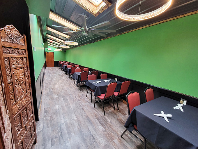 The dining area's vibrant green walls and carved wooden door create an unexpected oasis of calm. Those black tablecloths mean business—serious eating business.