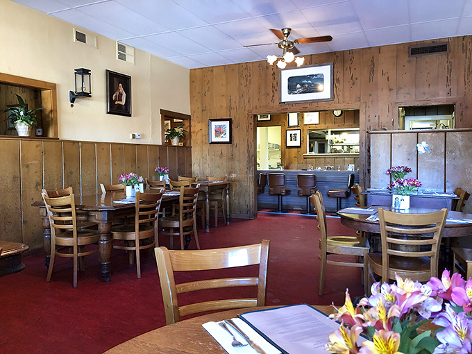 Red carpet floors meet wood-paneled walls in this dining room where fresh flowers remind you that beauty, like good food, needn't be complicated.