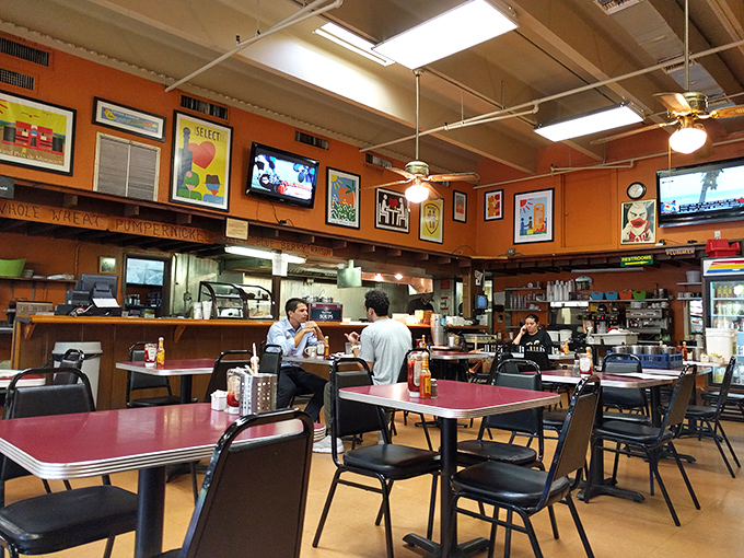 Red-topped tables and orange walls create the classic diner palette where conversations flow as freely as the coffee refills.