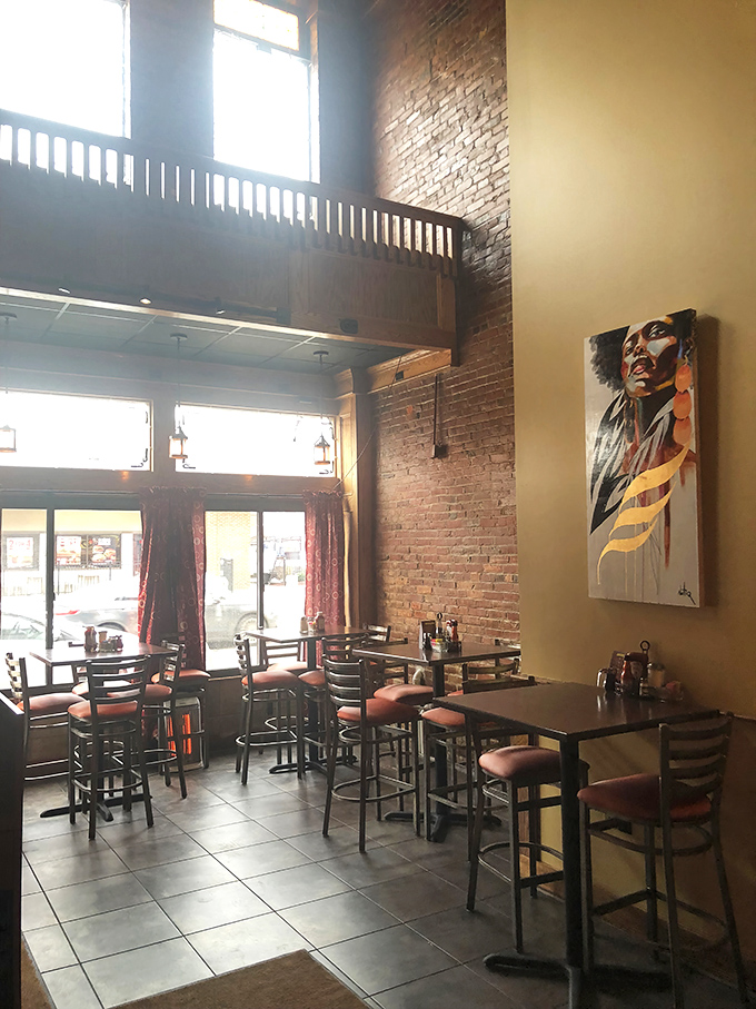 Sunlight streams through tall windows, illuminating a dining space where high-top tables and exposed brick create the perfect stage for soul food drama.