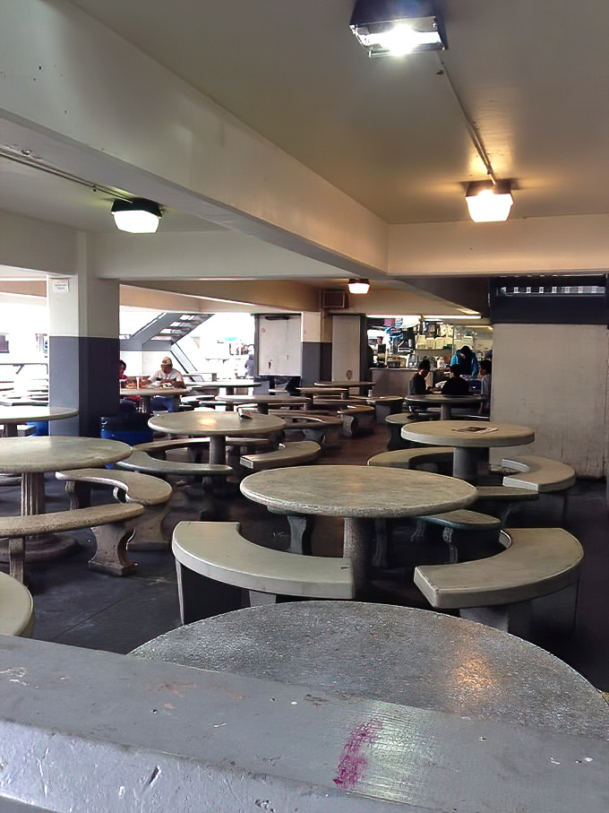 The dining area&mdash;no frills, just thrills. These concrete tables have witnessed more seafood euphoria than a fisherman's diary, all under fluorescent lighting.