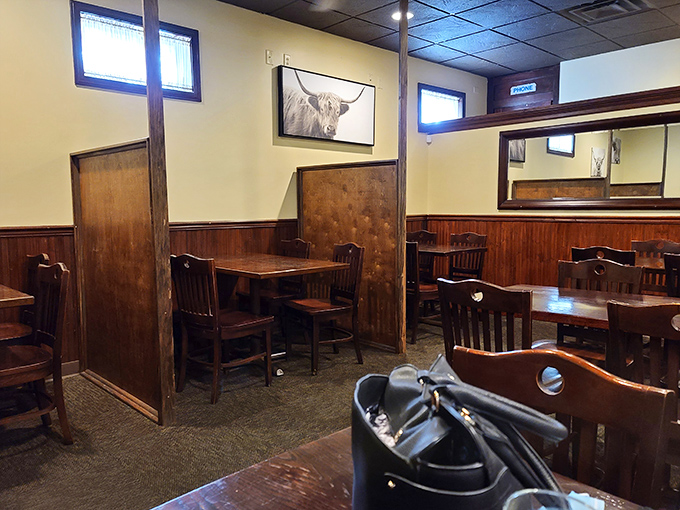 Wooden dividers create intimate dining nooks while the Highland cattle artwork reminds you what's for dinner. Rustic charm that whispers, "Stay awhile."