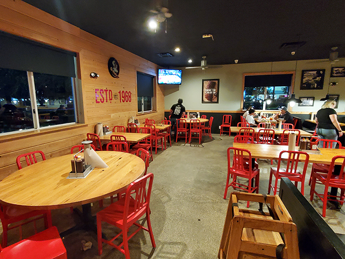 Red chairs pop against wooden walls in a dining room designed for one purpose: focusing entirely on what's on your plate.