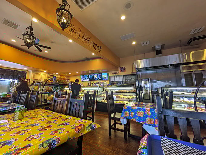 The dining area balances functionality with charm, where colorful tablecloths and ornate light fixtures create the perfect backdrop for serious eating.