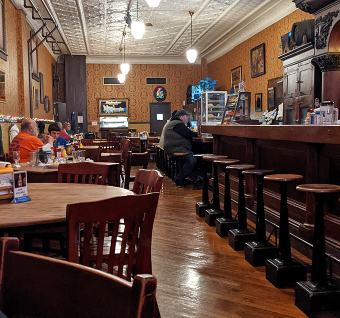 The dining room hums with conversation while the polished wood floors reflect decades of satisfied customers coming and going.