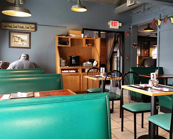 Green booth seating that whispers "stay awhile" beneath a sign that perfectly captures Jimmy's philosophy: Good Food, Good Friends, Good Times&mdash;the holy trinity of dining.