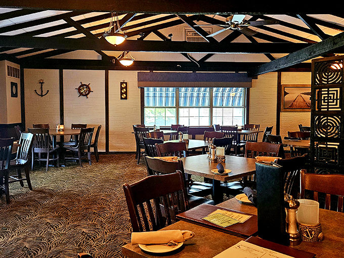 Daylight streams through windows illuminating a dining room where nautical meets rustic comfort &ndash; ship wheels and exposed beams creating the perfect seafood sanctuary.