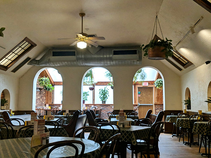 The dining area's arched windows and hanging plants create an oasis where time slows down and food tastes even better.