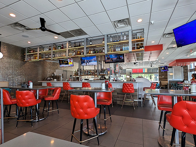 The bar area combines retro charm with modern comfort, those quilted red chairs practically begging you to settle in for "just one more bite."