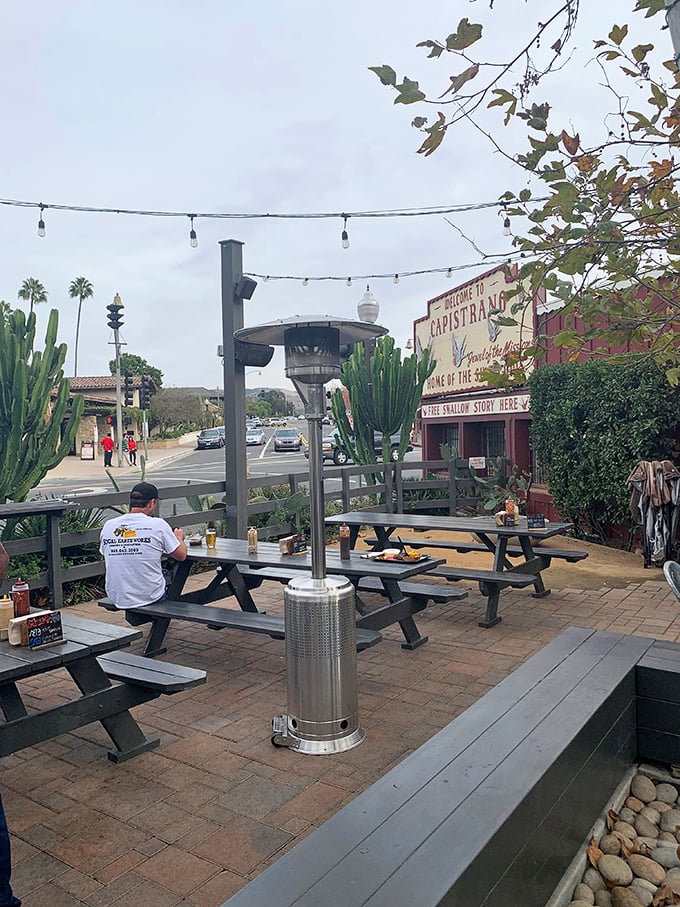 The outdoor seating area offers a quintessential California dining experience—palm trees, string lights, and the promise of barbecue bliss.