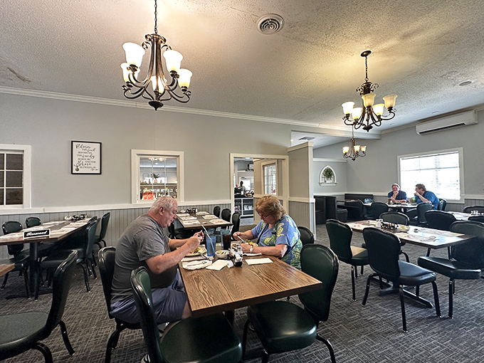 Elegant chandeliers cast a warm glow over simple wooden tables, creating a dining room that says, "Stay awhile, we've got pie."