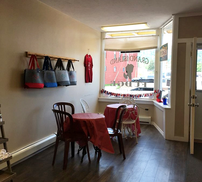 The cozy dining area offers a moment of respite, with charming red tablecloths and a view of Main Street. Simple pleasures in a simple setting.