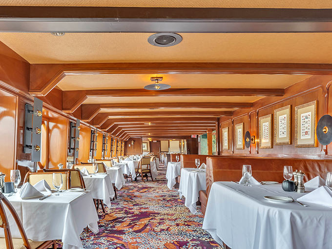 The dining room stretches like a ship's corridor into infinity, with warm wood tones and white tablecloths creating a portal to maritime elegance.