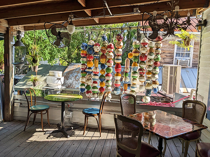 Colorful glass orbs dangle overhead while diners enjoy their meals in this whimsically decorated outdoor paradise that screams authentic Key West charm.