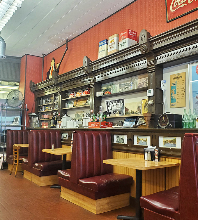Those burgundy booths have cradled more happy customers than a mattress showroom. The vintage back bar showcases treasures from simpler times.