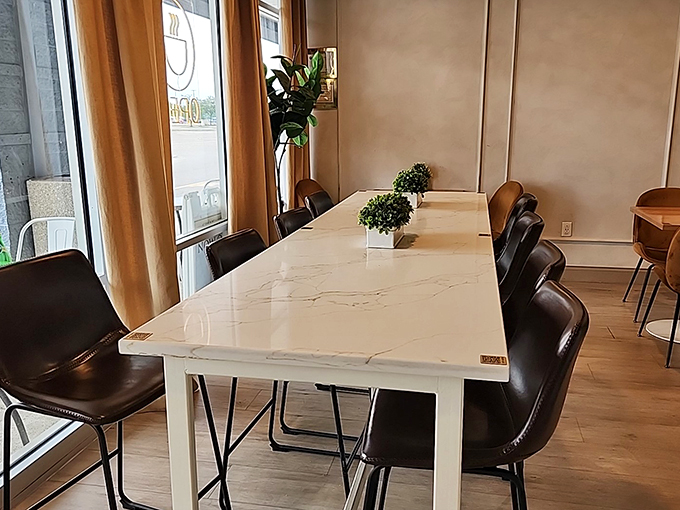 The marble communal table invites strangers to become friends over shared pastries. Some of life's best conversations happen in spaces like this.