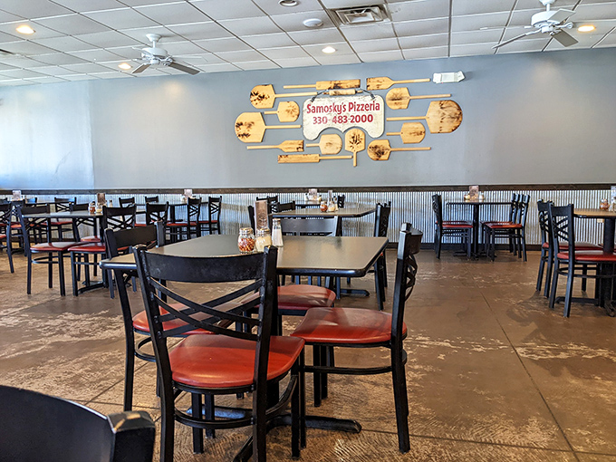 The dining area's wall art celebrates pizza-making heritage with wooden paddles that have seen more action than a Hollywood stuntman.