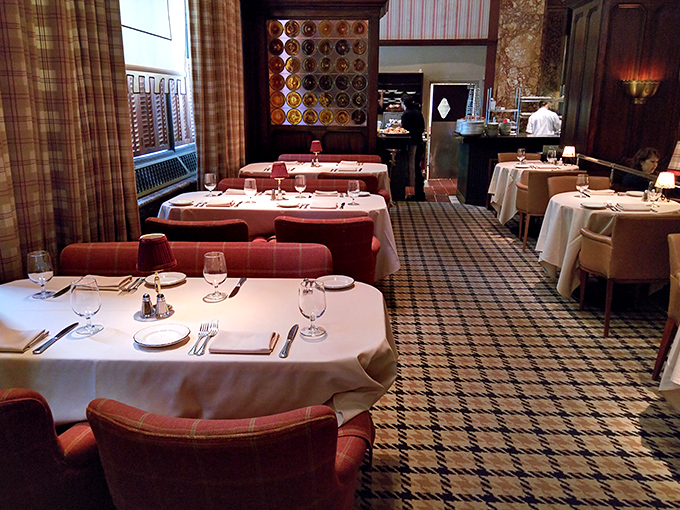 The dining room's plaid accents and crisp white tablecloths create an atmosphere that's simultaneously cozy and elegant. Like dining in a sophisticated Scottish castle.