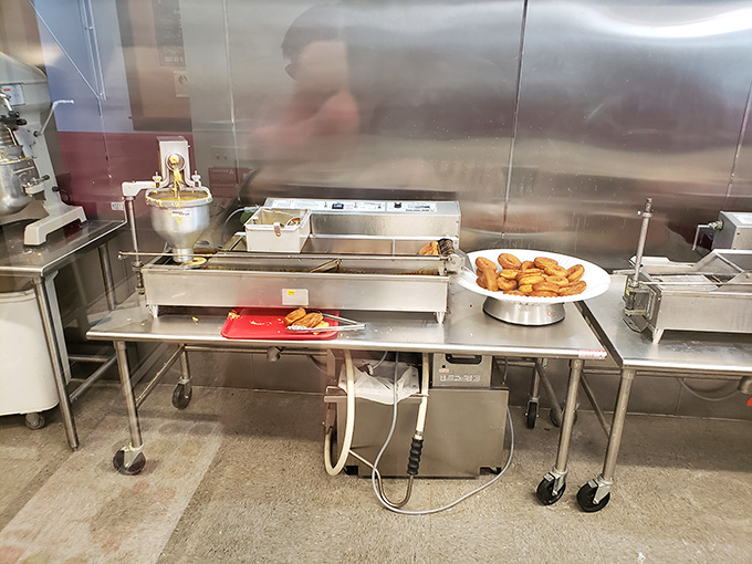 The donut assembly line where fresh rings of dough become your personalized breakfast destiny.