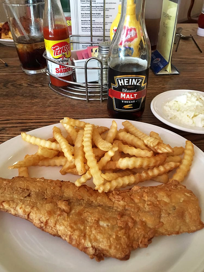 Golden fish, crinkle-cut fries, and all the condiments you need. This plate is why malt vinegar was invented.