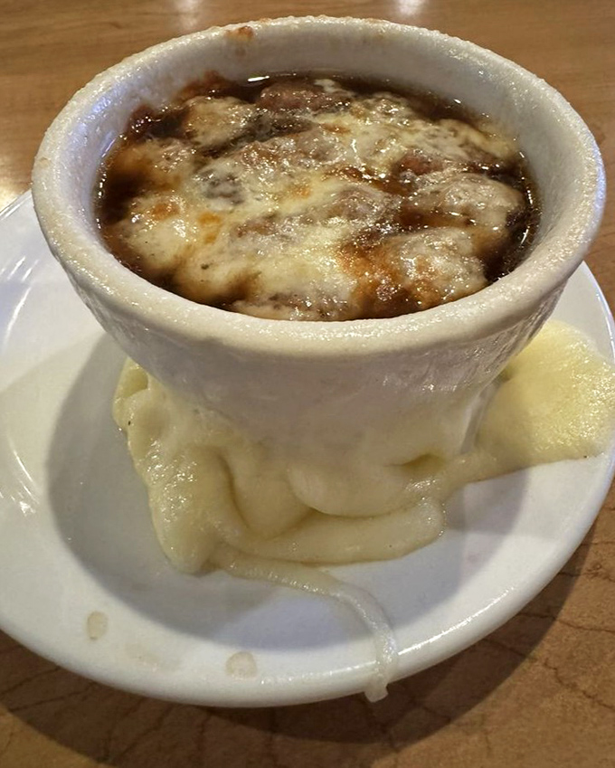 French onion soup with a cheese cap so perfect it deserves its own superhero cape. The mashed potatoes below are the sidekick we all need.