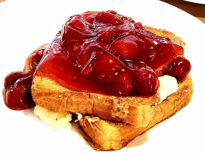French toast drowning happily in a cherry sea. This isn't breakfast&mdash;it's dessert with a morning alibi, and we're not complaining one bit.