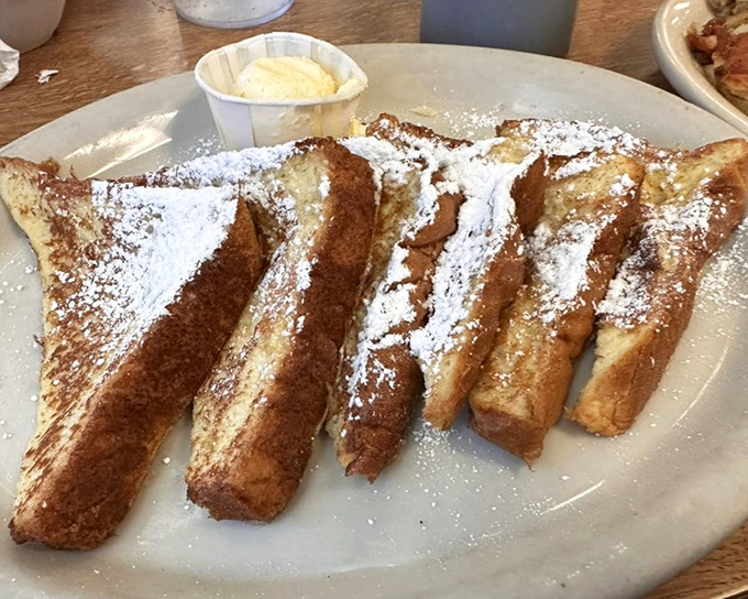 French toast that makes regular bread feel inadequate. Dusted with powdered sugar like fresh snow on a mountain that you'll happily climb with your fork.