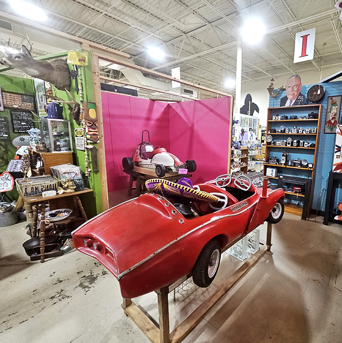 A child-sized vintage convertible sits proudly on display. Someone's cherished childhood ride now waits for its next adventure or a nostalgic collector.