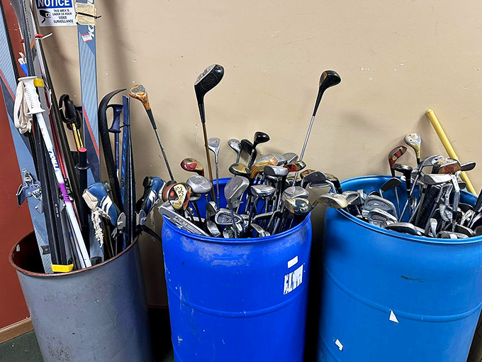 Golf clubs hibernating in blue barrels, dreaming of green fairways instead of fluorescent lights. Someone's abandoned hobby awaits your enthusiasm.