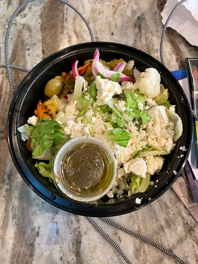 A Greek salad that actually looks like someone cared when they made it&mdash;fresh, vibrant, and a noble attempt at balancing out the pizza.