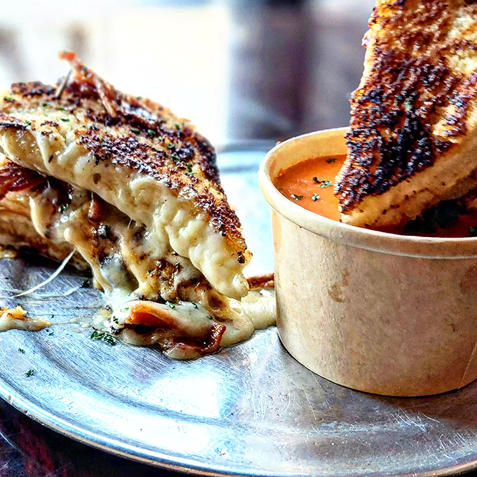 Not your childhood grilled cheese – this grown-up version with its melty perfection and tomato soup sidekick is comfort food that's earned a PhD.