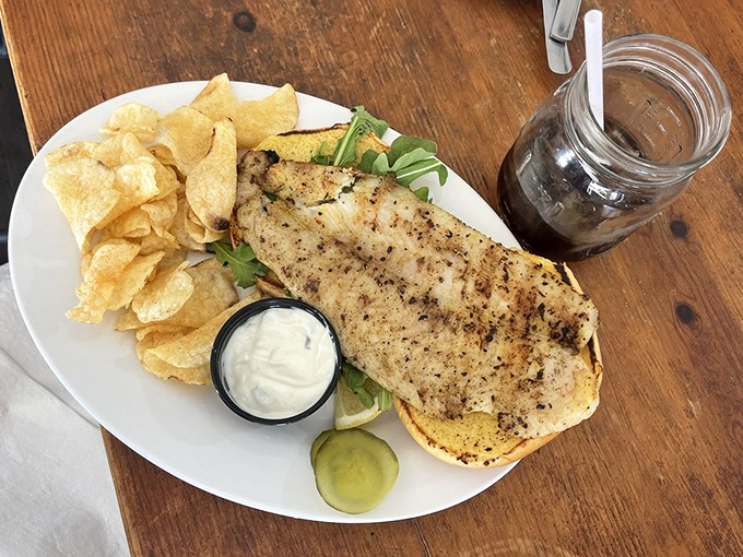 This isn't just a sandwich; it's a perfectly grilled catfish vacation on a bun with all the right accessories.