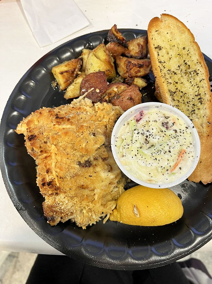 Simple perfection: a golden-crusted fish fillet, roasted potatoes, and garlic bread for sopping up every last bit of flavor. No pretension, just deliciousness.