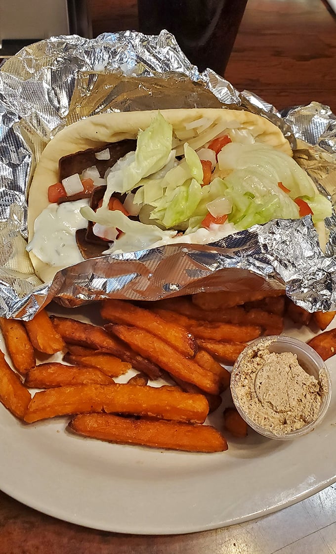 A gyro wrapped in foil like the gift it is, with sweet potato fries that blur the line between side dish and dessert.