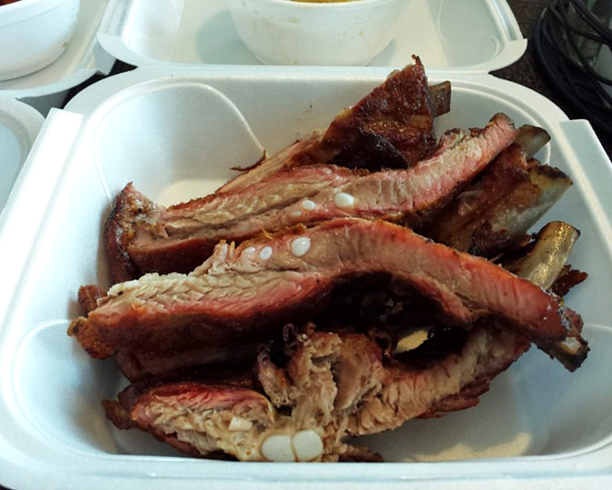 Ribs with that perfect pink smoke ring that BBQ aficionados chase like treasure hunters. The meat isn't falling off the bone&mdash;it's respectfully departing.