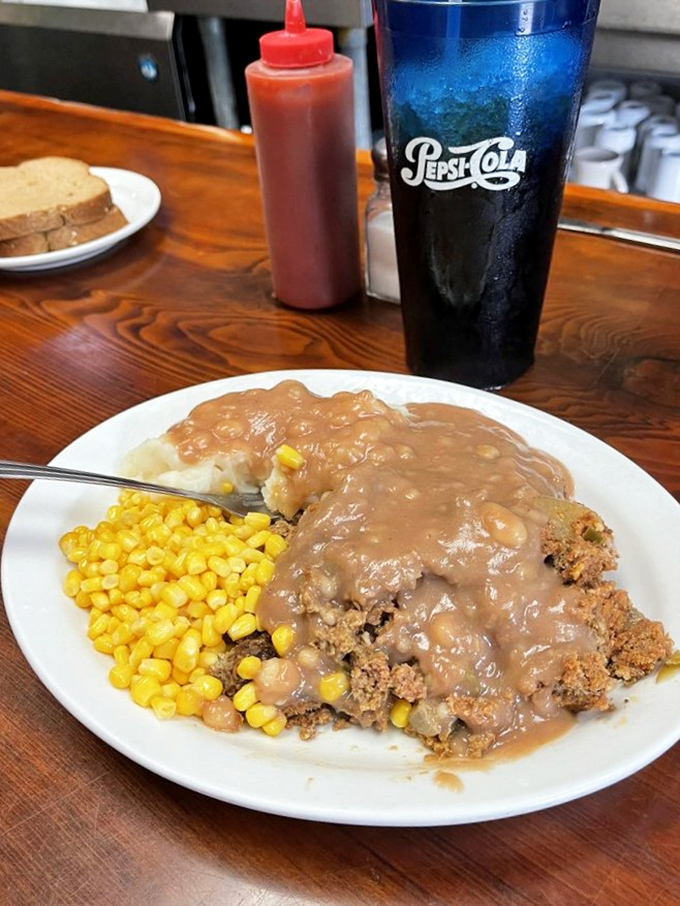Homestyle meatloaf swimming in gravy with a side of sweet corn. The kind of meal that makes you want to hug the cook.