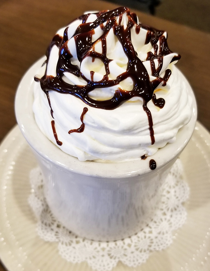 Hot chocolate that understands the importance of proper whipped cream architecture. That chocolate drizzle is pure artistry.