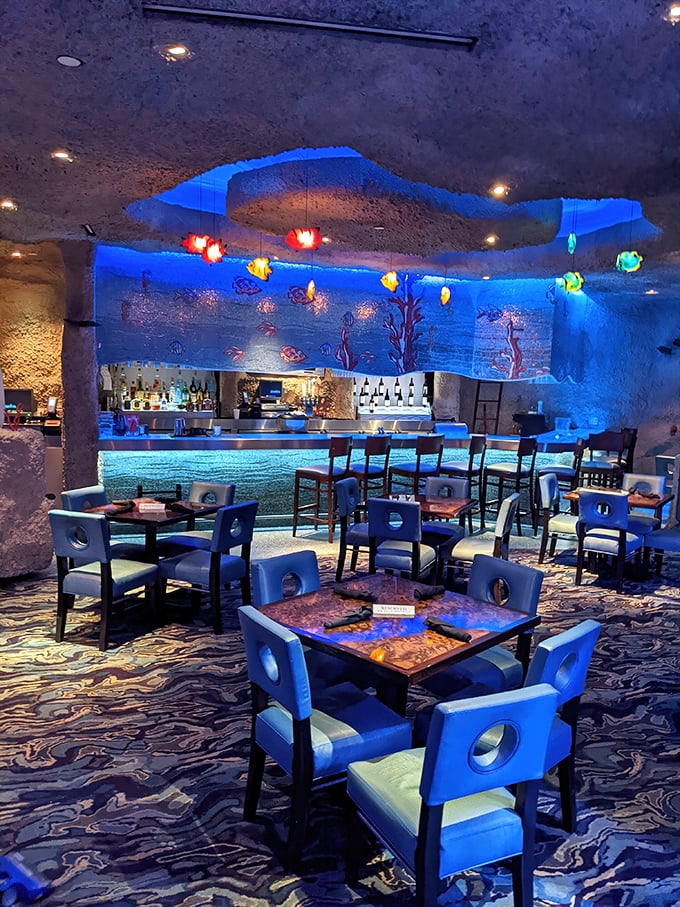 The bar area glows with an ethereal blue light that makes everyone look like they've been professionally filtered for Instagram.