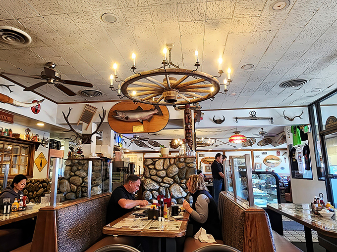 Rustic chandeliers and fishing decor create an atmosphere where every meal feels like a gathering of old friends.