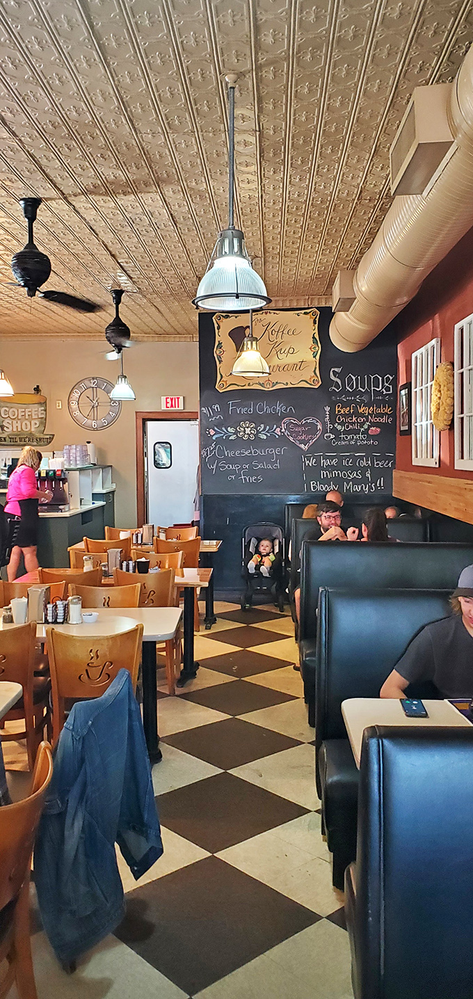 Classic black and white checkered floors beneath a ceiling of vintage tin &ndash; where every table tells a story and every booth holds a memory.