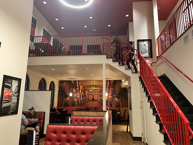 The two-story interior with its dramatic red staircase feels like the set of a movie where the plot revolves around an exceptional dining experience.