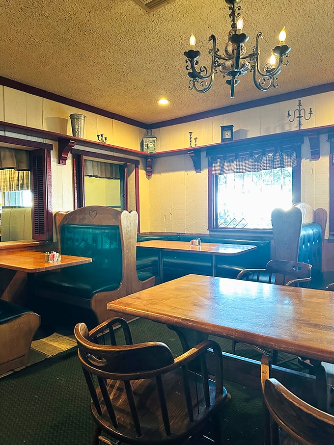 High-backed booths and wooden tables create intimate dining spaces beneath charming chandeliers&mdash;country dining with a touch of elegance.