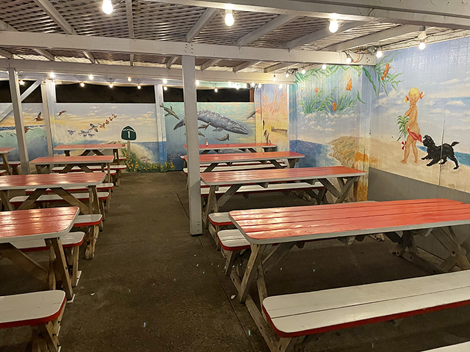 Evening dining under string lights with ocean-themed murals. Like eating in an aquarium, but the fish is on your plate, not swimming by.