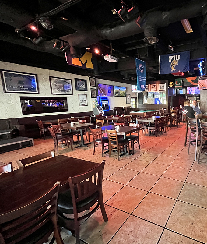 The tavern side reveals its sports bar soul with university flags and enough screens to follow every game without neck strain.