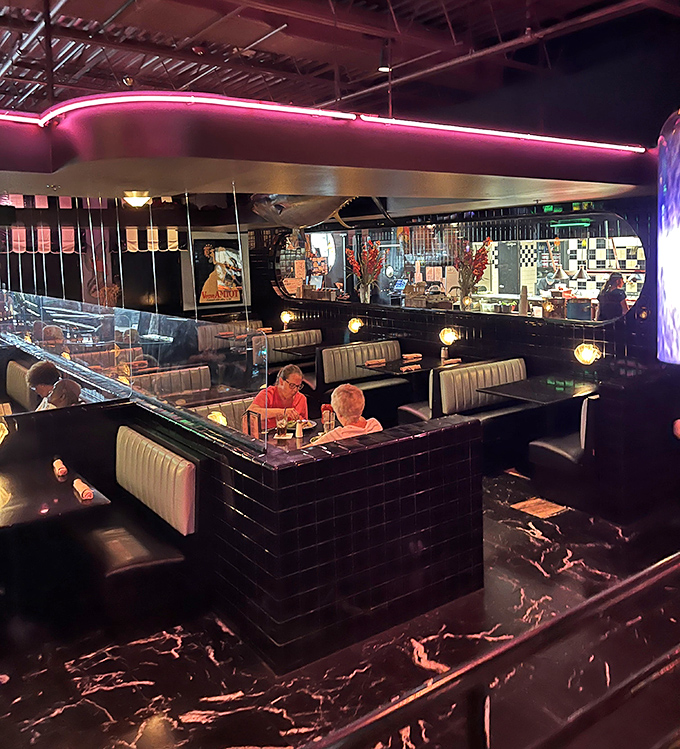 Booths that invite intimate conversations and lingering meals. The black and white checkered accents add a touch of nostalgic charm to this sophisticated dining space.
